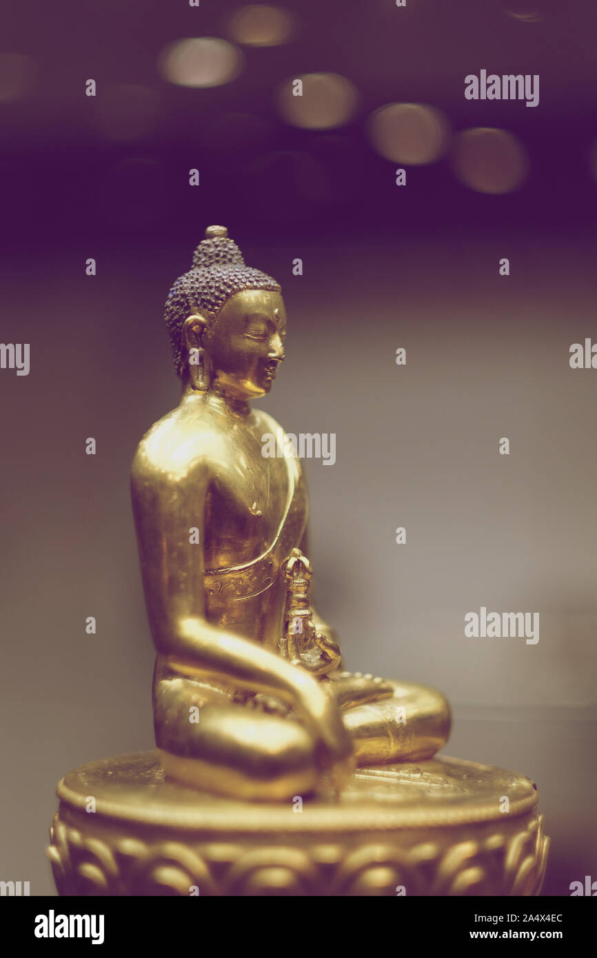 Figurine of the oriental Buddhist deity sitting in a meditation pose ...