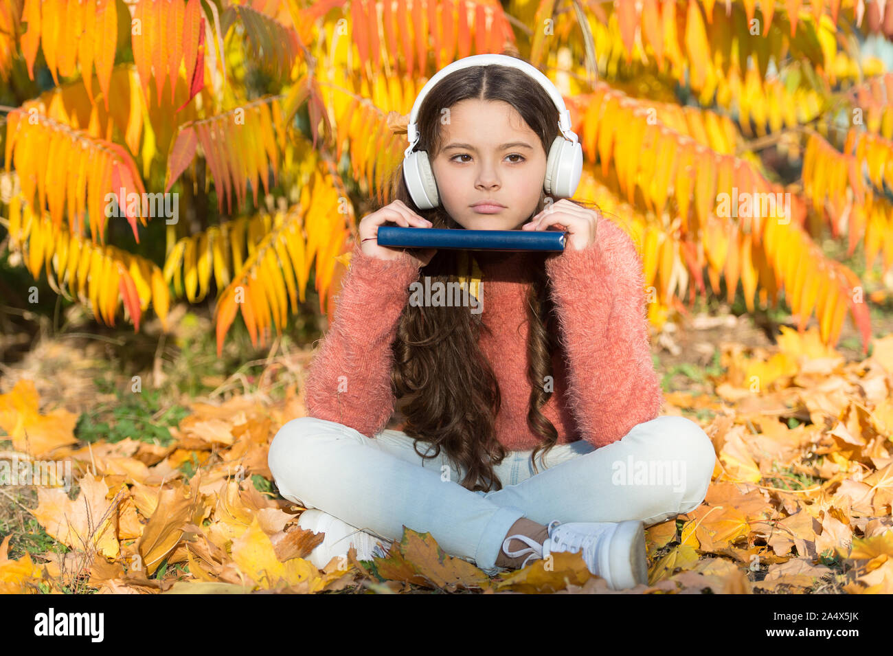 eLearning today. Little girl learning online under tree with yellow ...