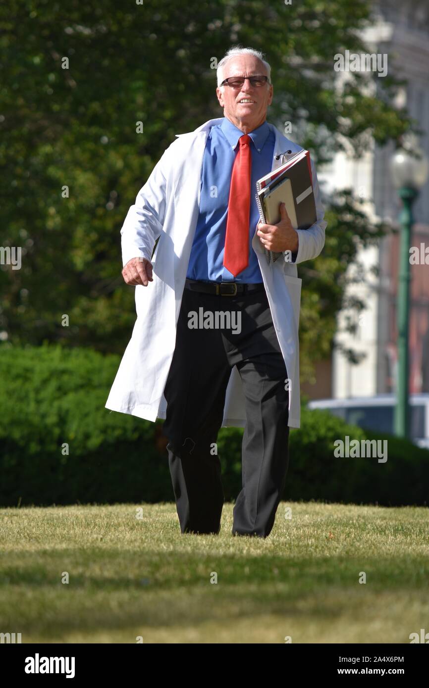 Handsome Male Doctor Smiling Wearing Lab Coat Walking Stock Photo - Alamy