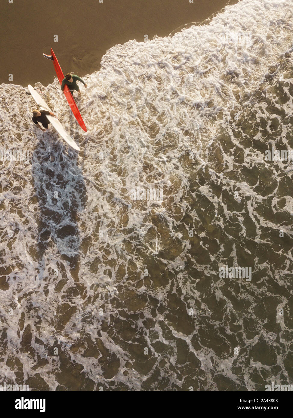 Aerial view of surfers at the beach Stock Photo - Alamy
