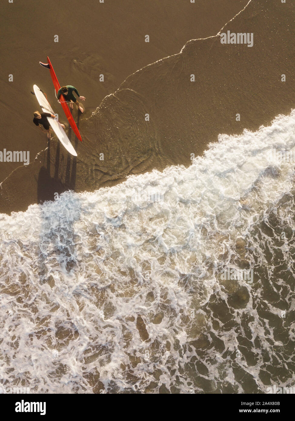 Aerial view of surfers at the beach Stock Photo - Alamy