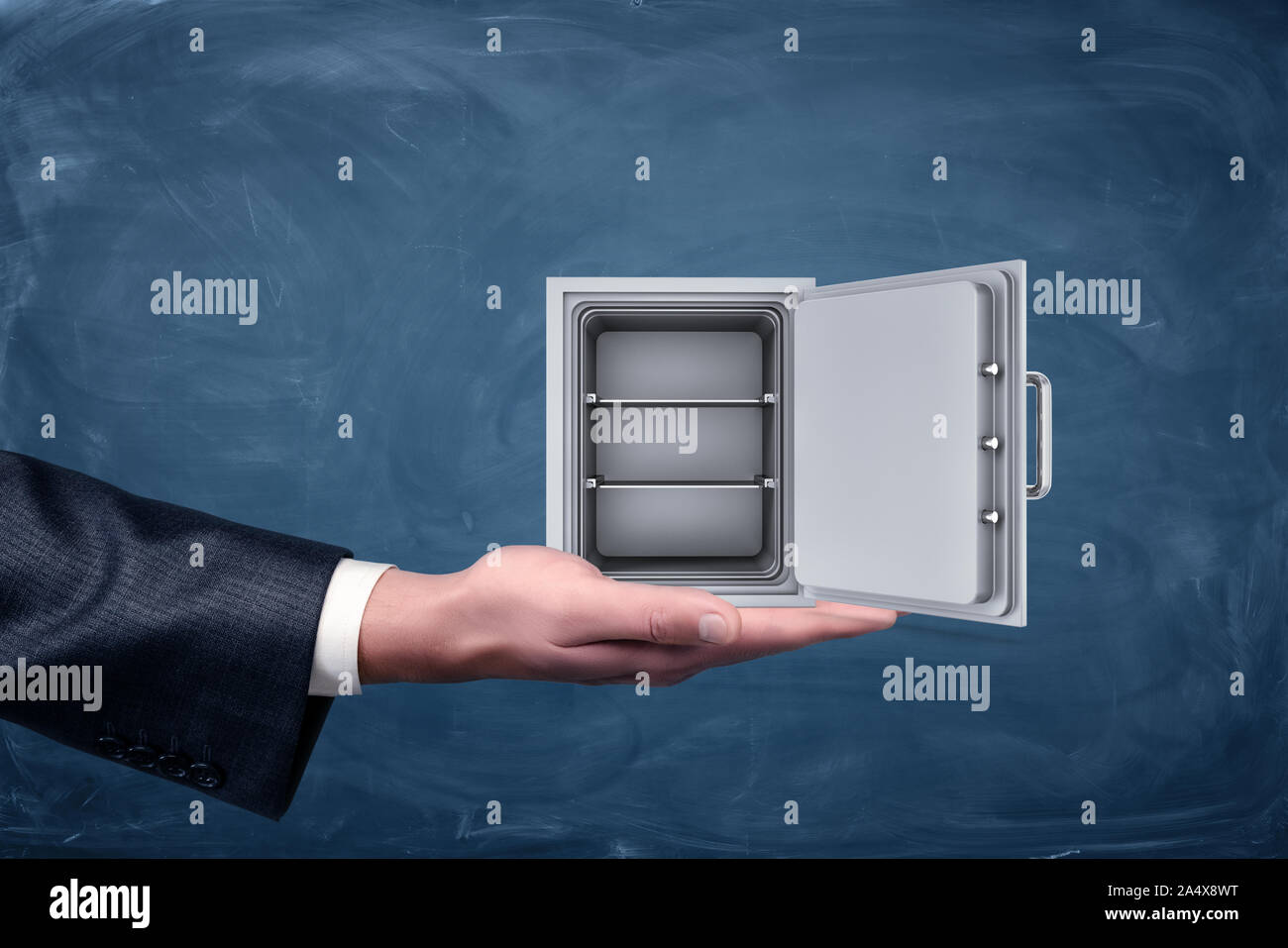 A businessman's hand on blue chalkboard background holding a silver ...