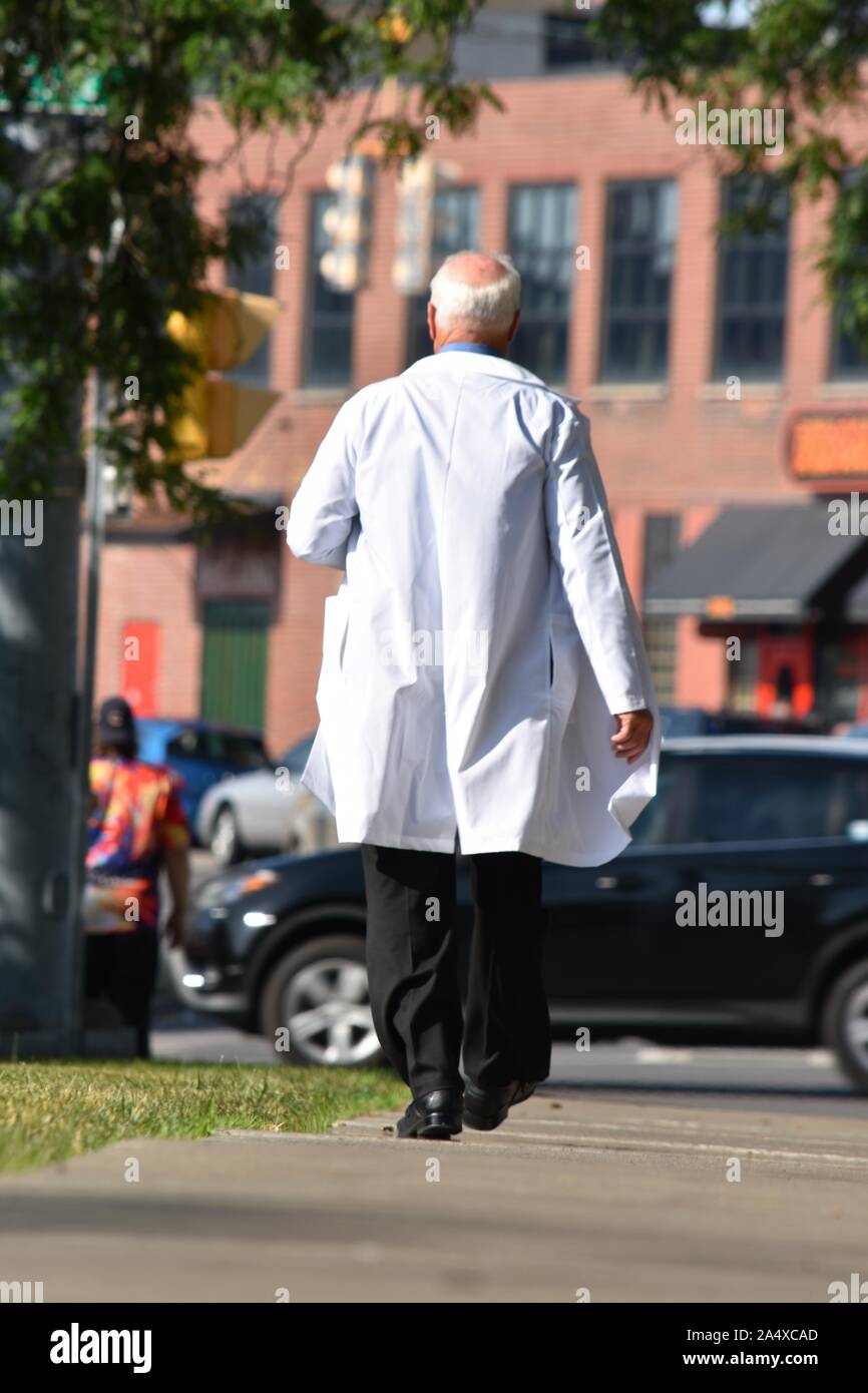 Senior Balding Male Doctor Walking On Sidewalk Stock Photo - Alamy