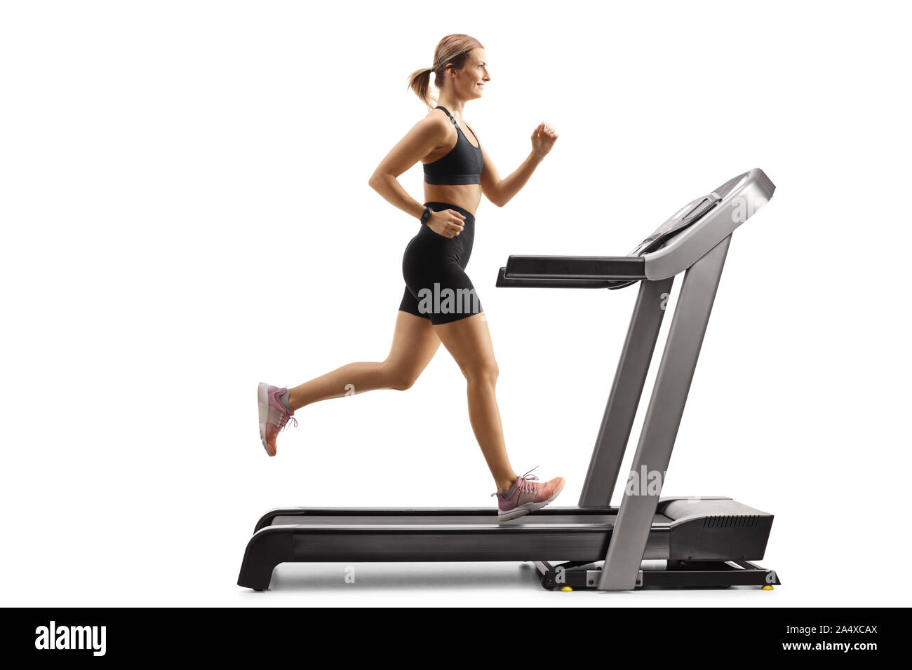 Full length profile shot of a fit woman running on a treadmill and ...