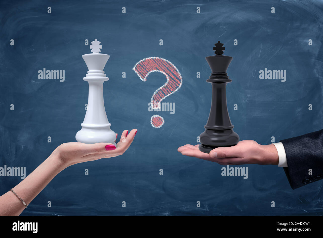 A chalk question mark between a female hand with a white chess king and ...