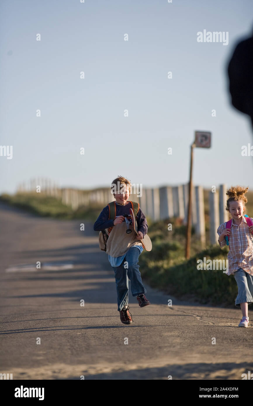 Brother and sister walking home from school together Stock Photo - Alamy