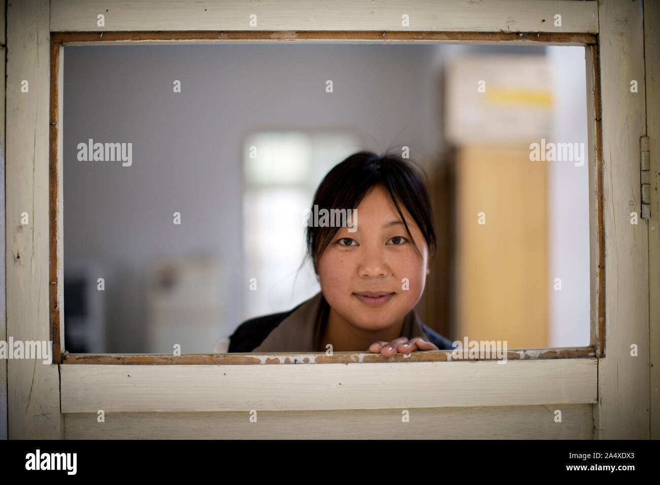 Portrait of woman peering through at gap at the top of a door Stock ...