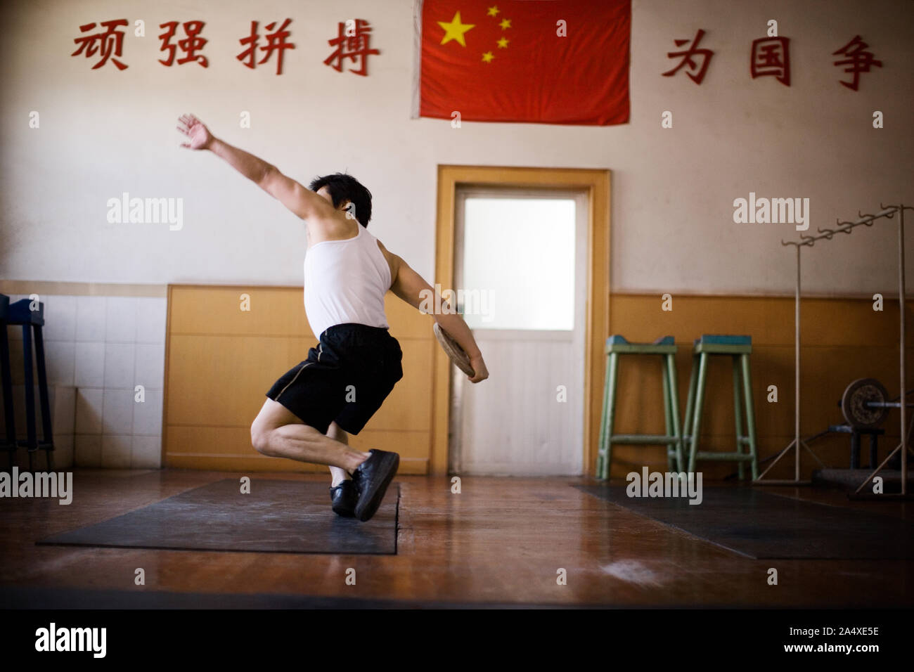 Teenage boy spinning while holding a weight in a gym Stock Photo - Alamy