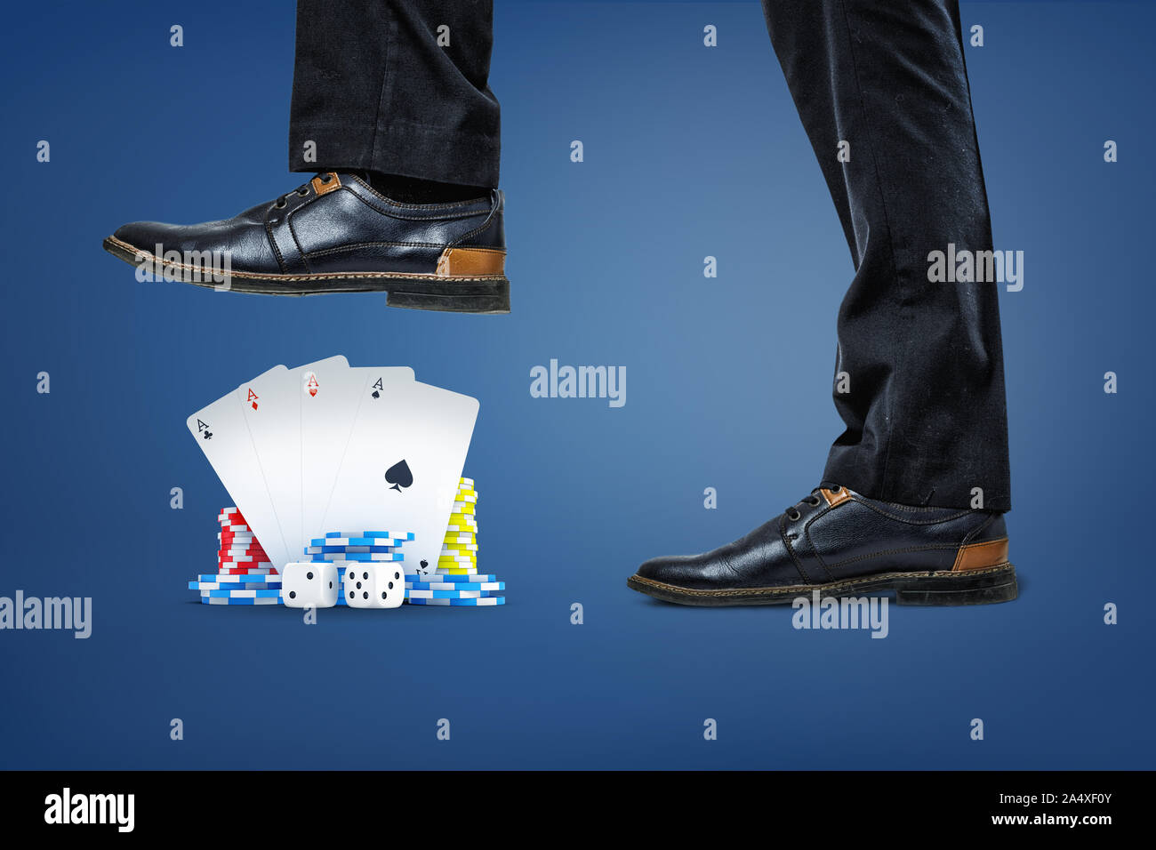 Businessman's shoes stepping on pack of cards, dice and stacks of chips ...