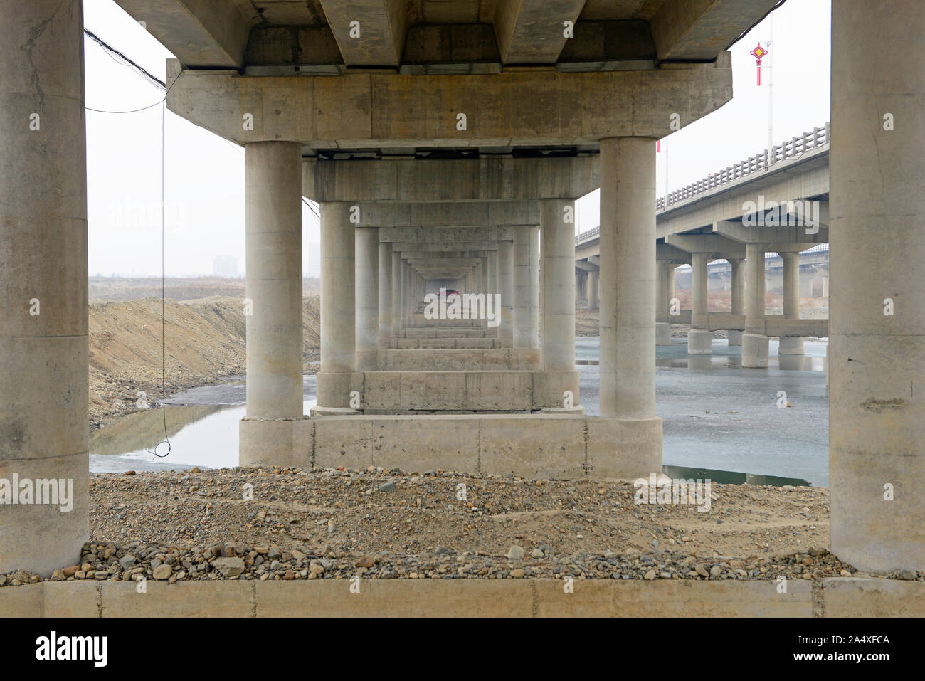 Underneath the road bridge across the frozen Hunchun river towards ...