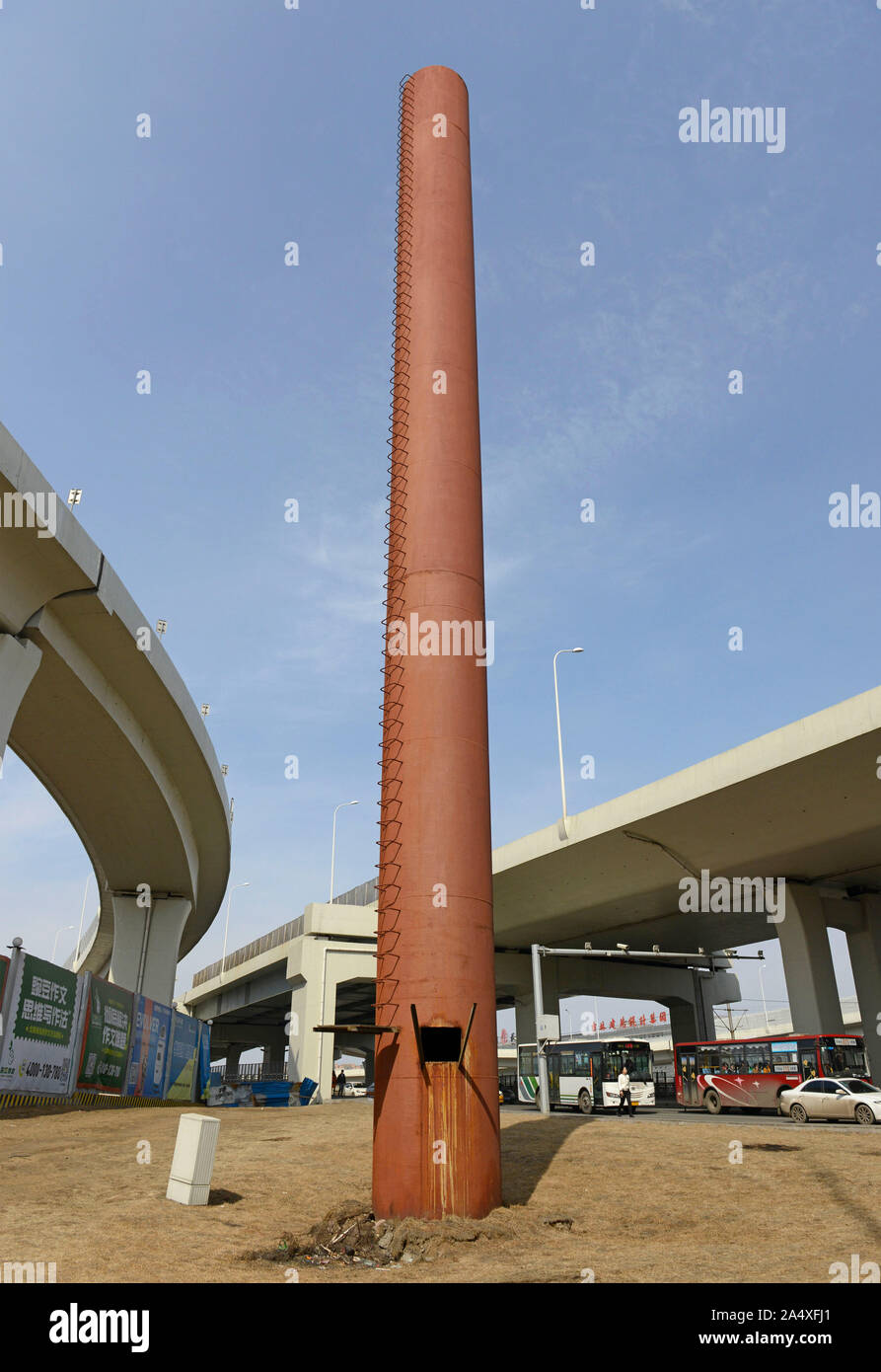 An old metal chimney at the junction of ground level and elevated roads ...