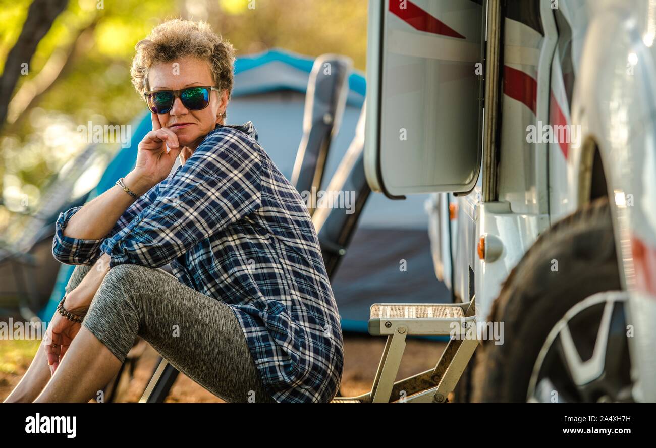 Travel Theme. Caucasian Woman in Her 60s Seating on the Side Motorhome ...