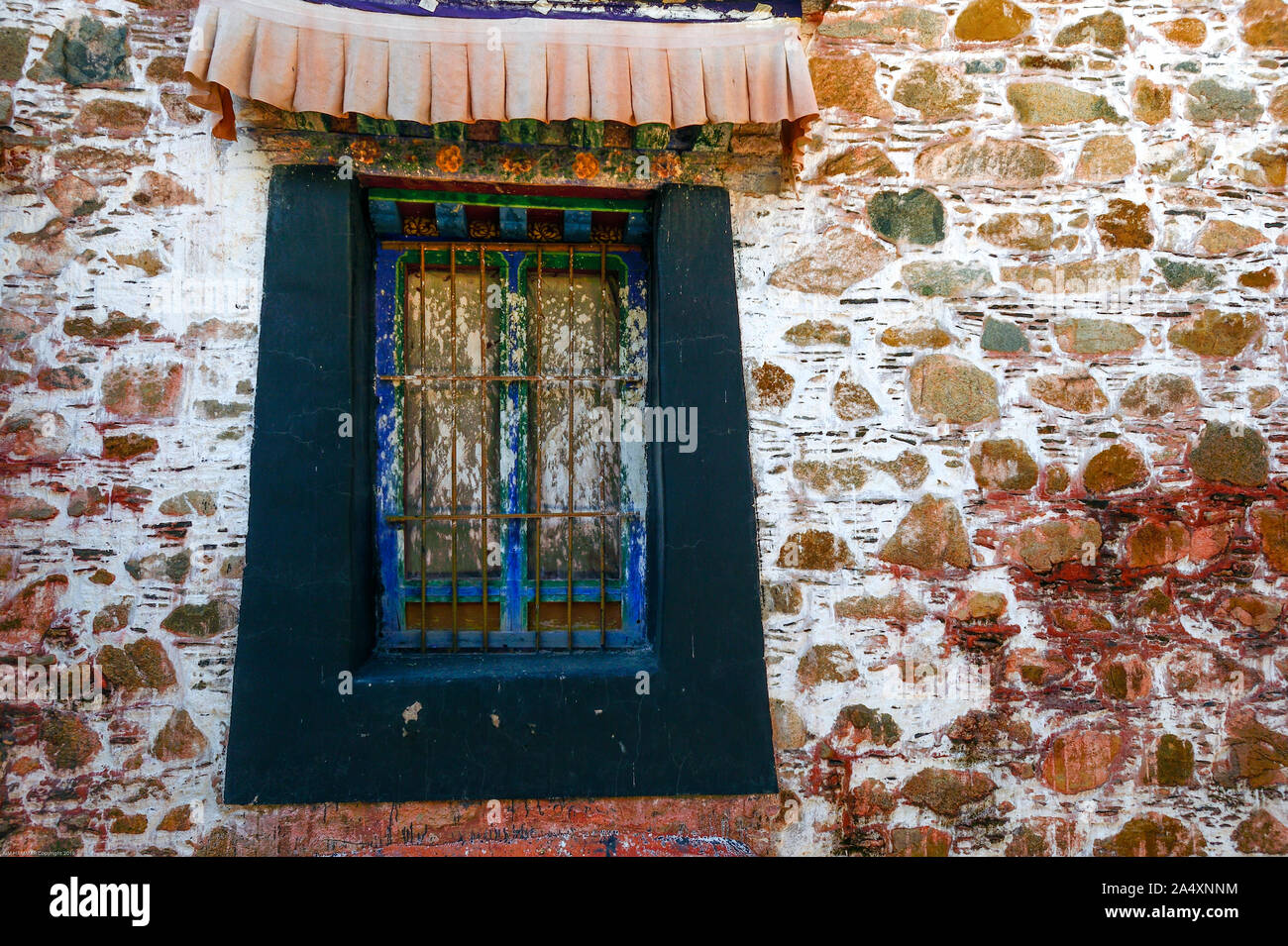 A brightly painted rock wall surrounds a decaying window at Deprung ...
