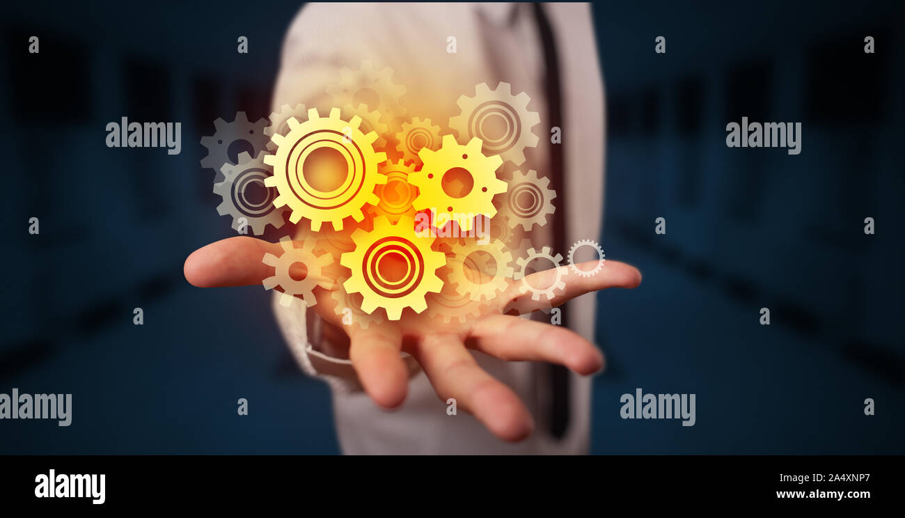 Hand holding gears in his hand Stock Photo - Alamy