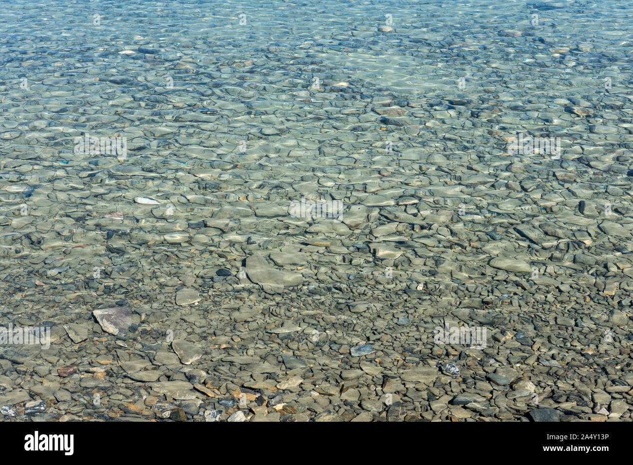 Closeup image of the stone under blue water in the lake Stock Photo - Alamy