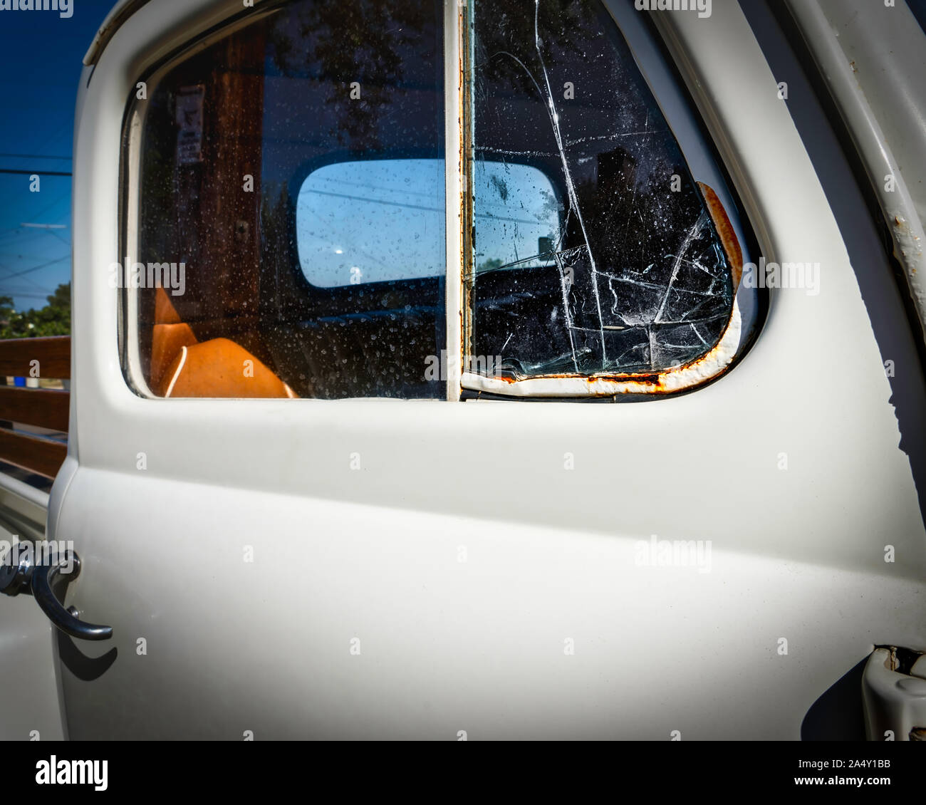 The broken window on an old 1949 pickup truck sitting on a street in ...