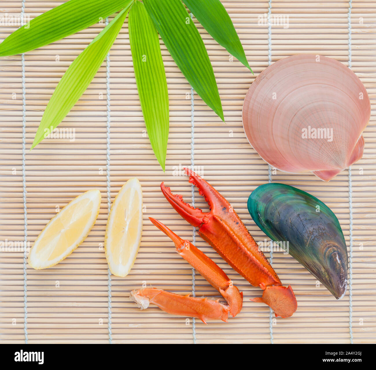 Raw queen scallops ,mussel and crab claws with lemon slice on bamboo ...