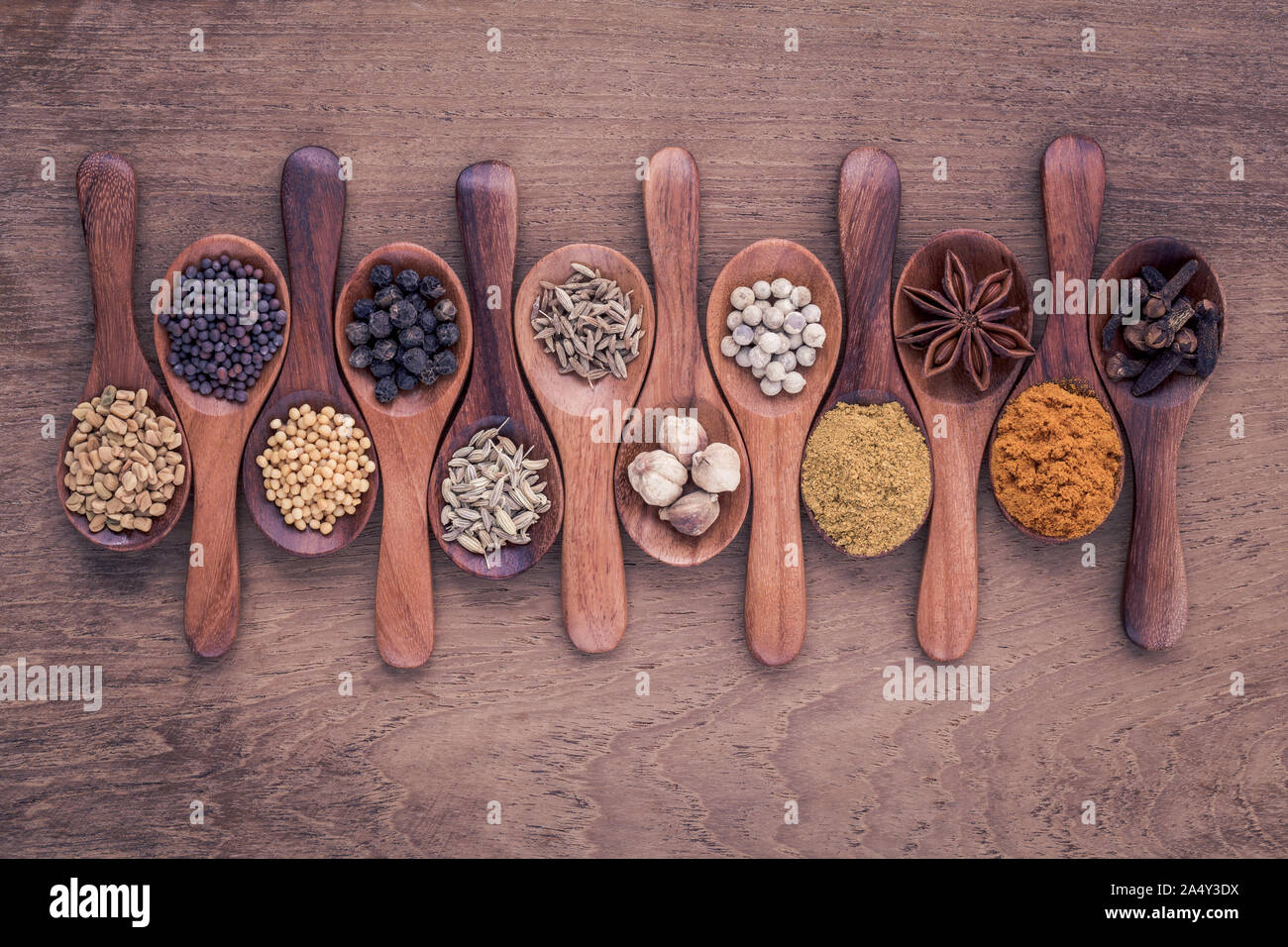 Assorted of spices in wooden spoon black pepper ,white pepper, black ...