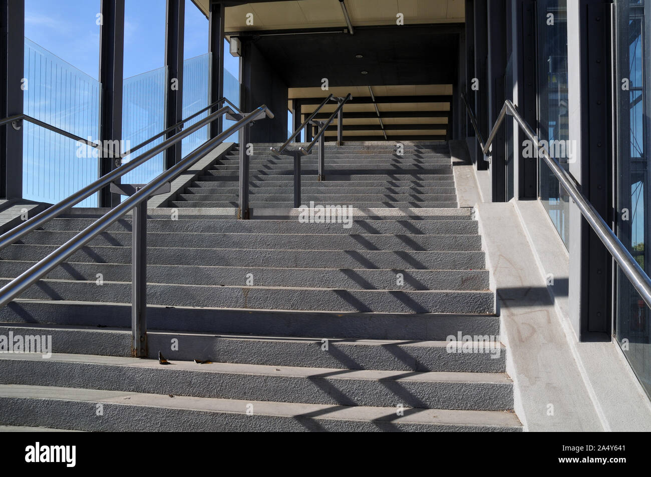 cement steps ascending to pedestrian bridge with glass front, urban ...
