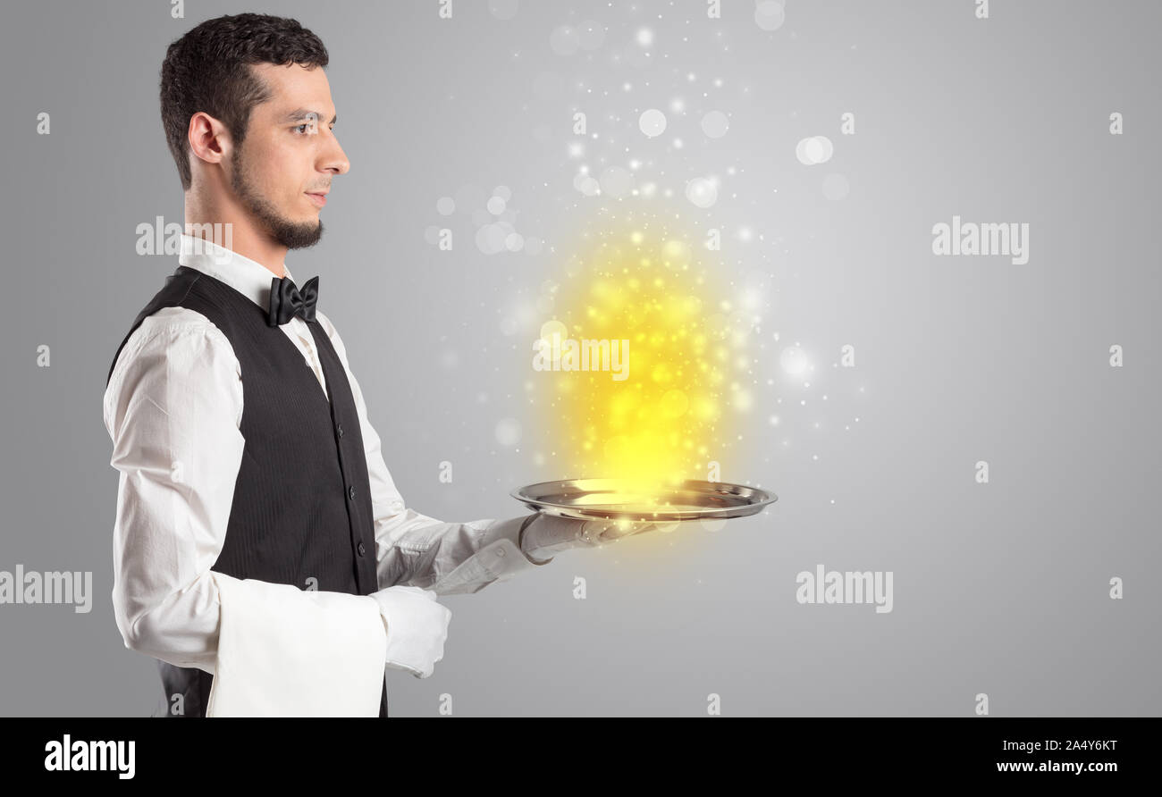 Elegant young waiter serving mysterious light on tray Stock Photo - Alamy