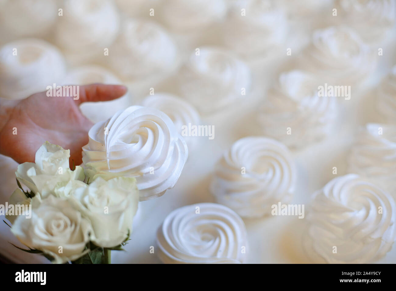Preparation of a white meringue cake Pavlova. Meringue swirls on a ...