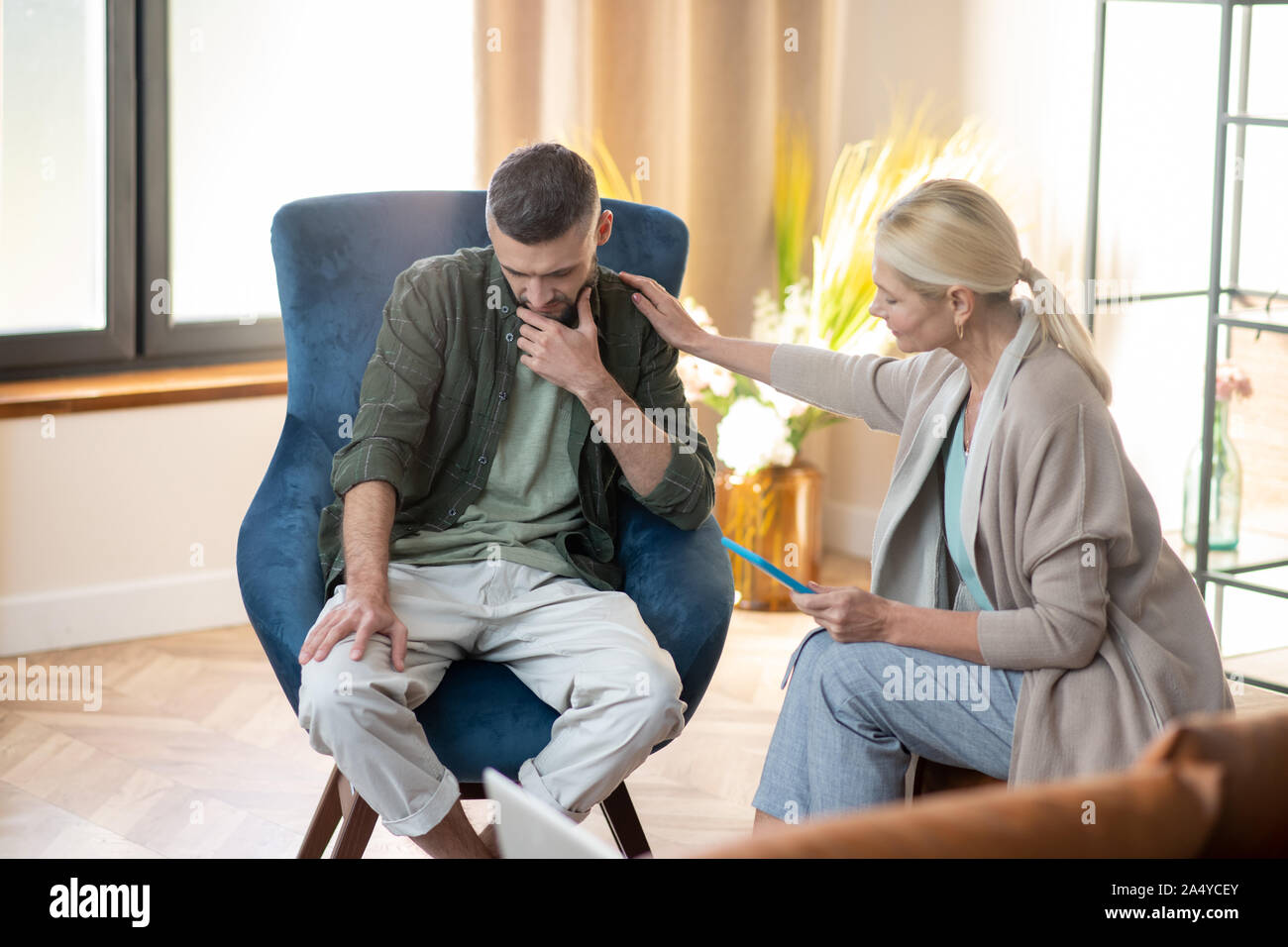 Psychologist touching shoulder of client while supporting him Stock ...