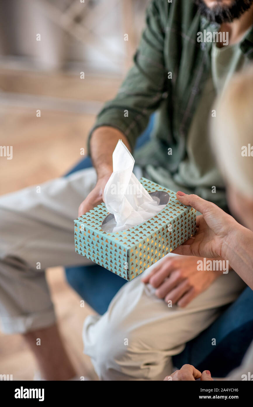 Close up of psychoanalyst giving pack of napkins to patient Stock Photo ...