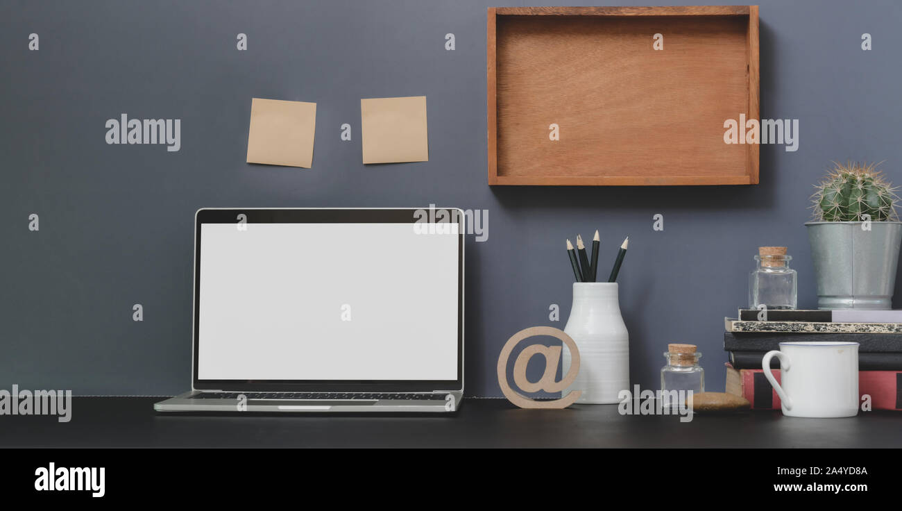 Open blank screen laptop computer in modern workspace with decorations ...