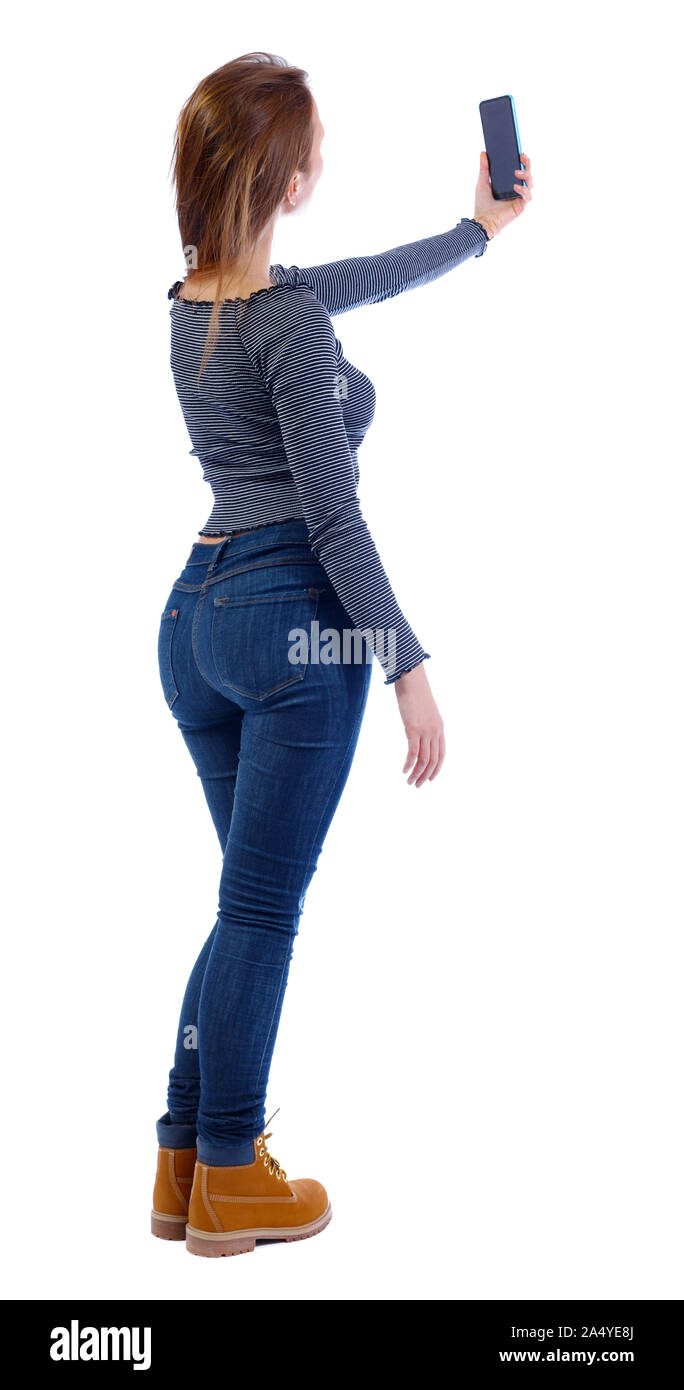 Back view of a woman who makes selfie with a smartphone. girl watching ...