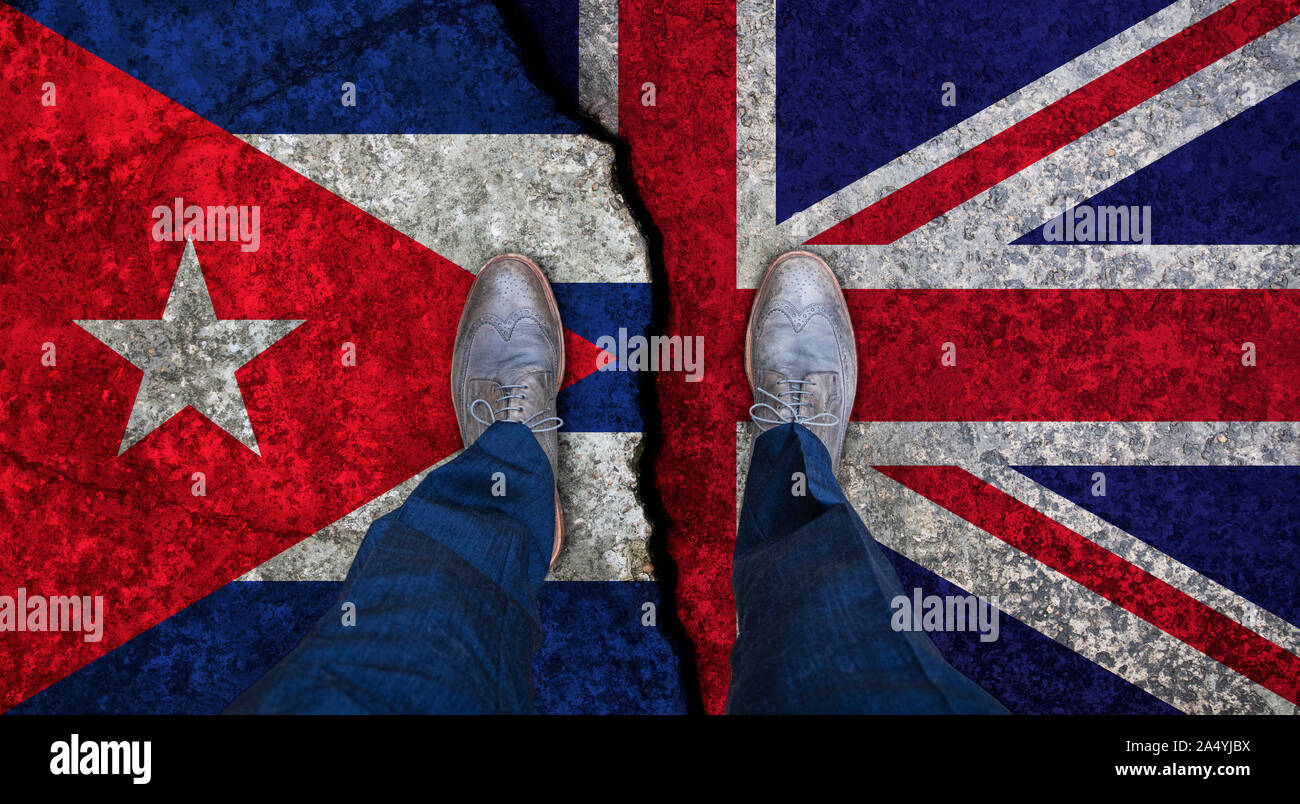 Business man stands on cracked flag of UK and Cuba. Political concept ...