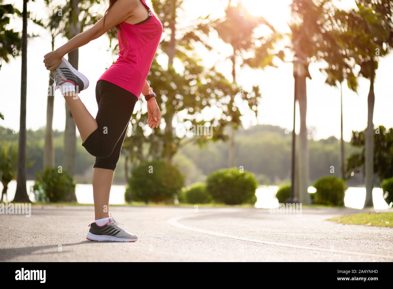 Young Fitness Woman Runner Stretching Legs Before Run In The Park