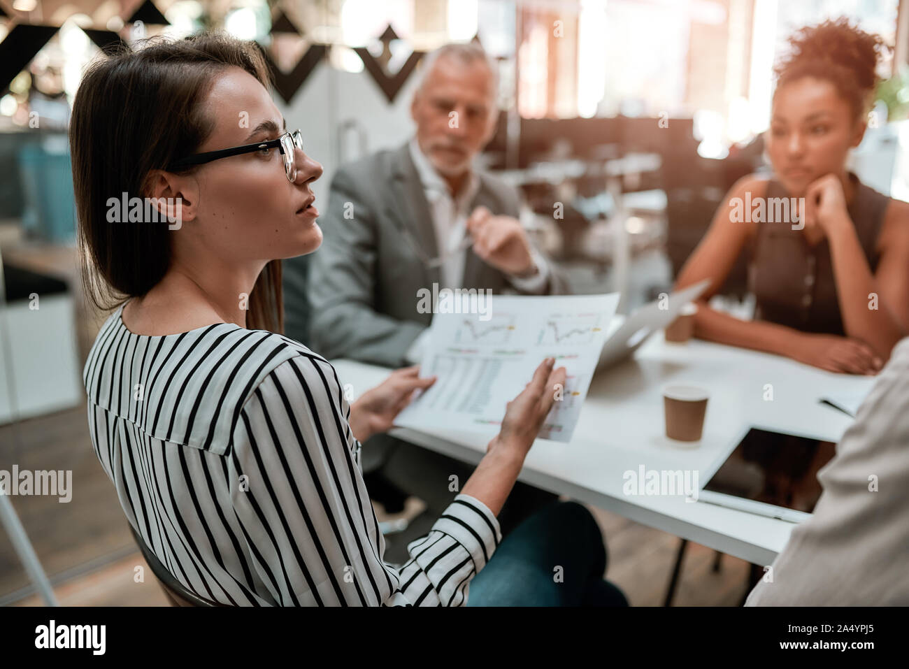 Analyzing results. Young business woman holding financial report and ...