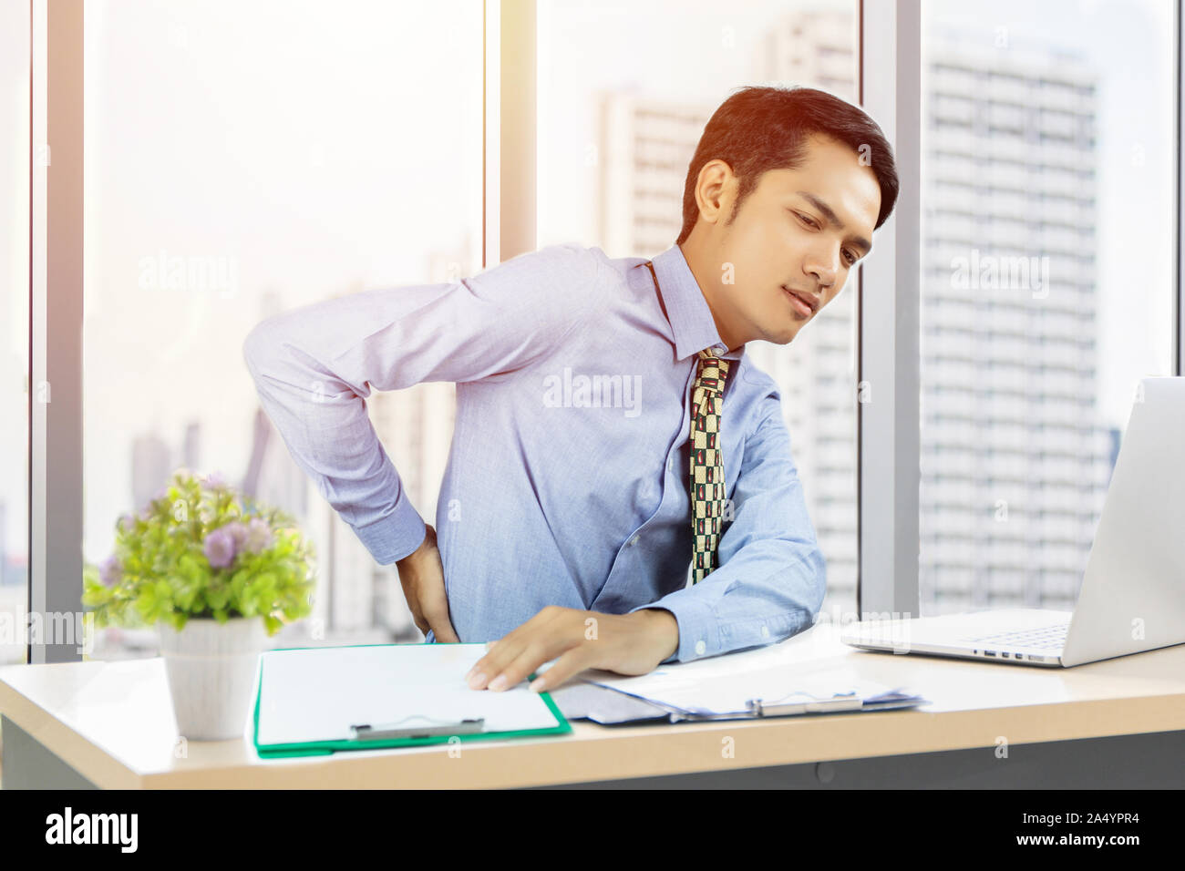 Asian Business men with back pain sin an office and serious about the ...