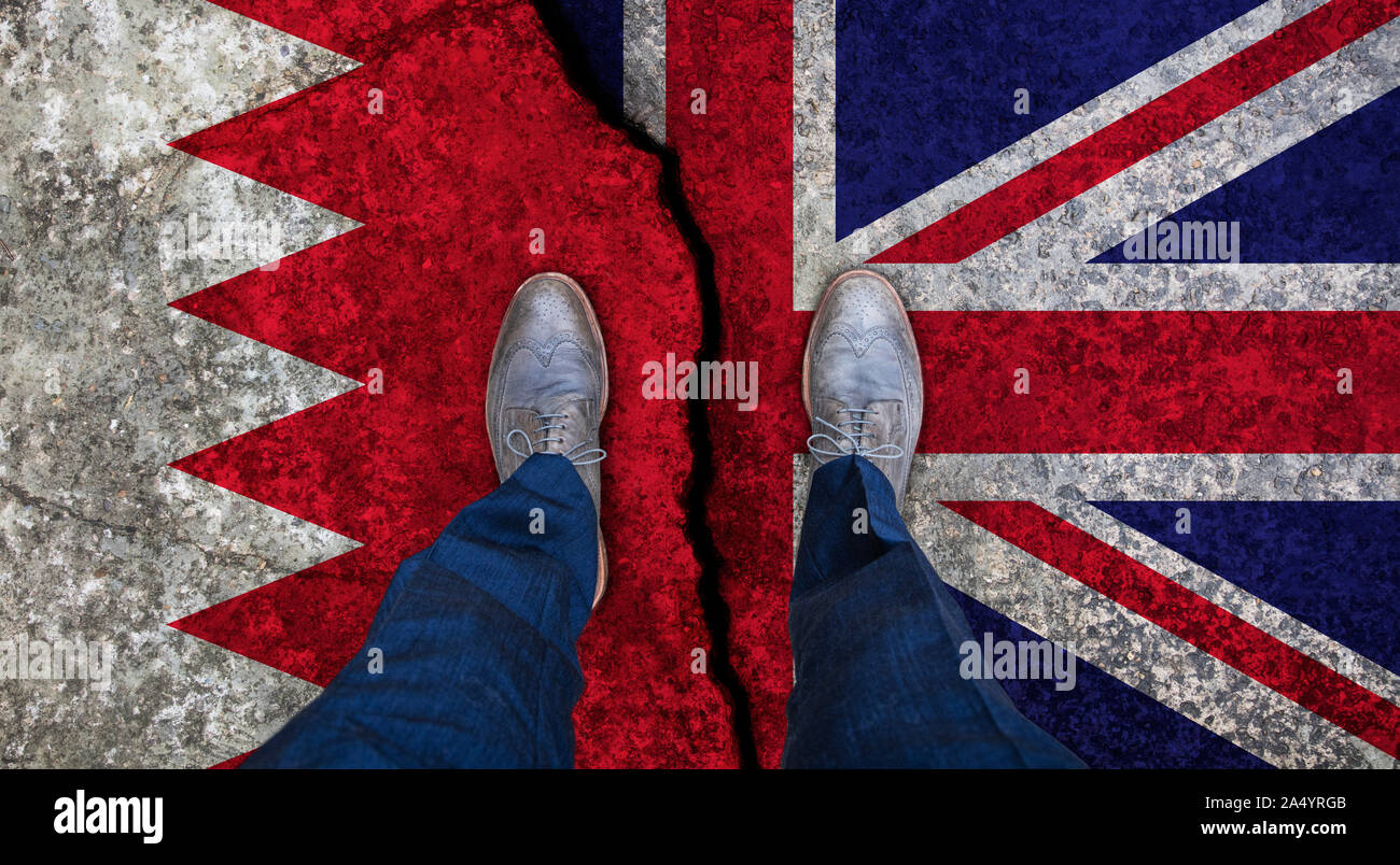 Business man stands on cracked flag of UK and Bahrain. Political ...