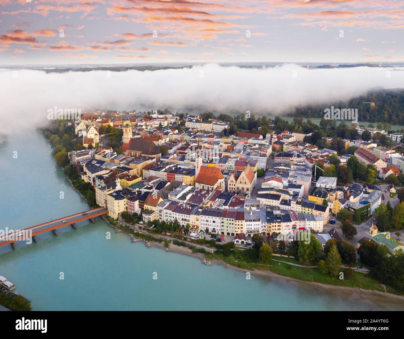 Old town in river loop of the Inn at dawn and fog, Red Bridge, moated ...