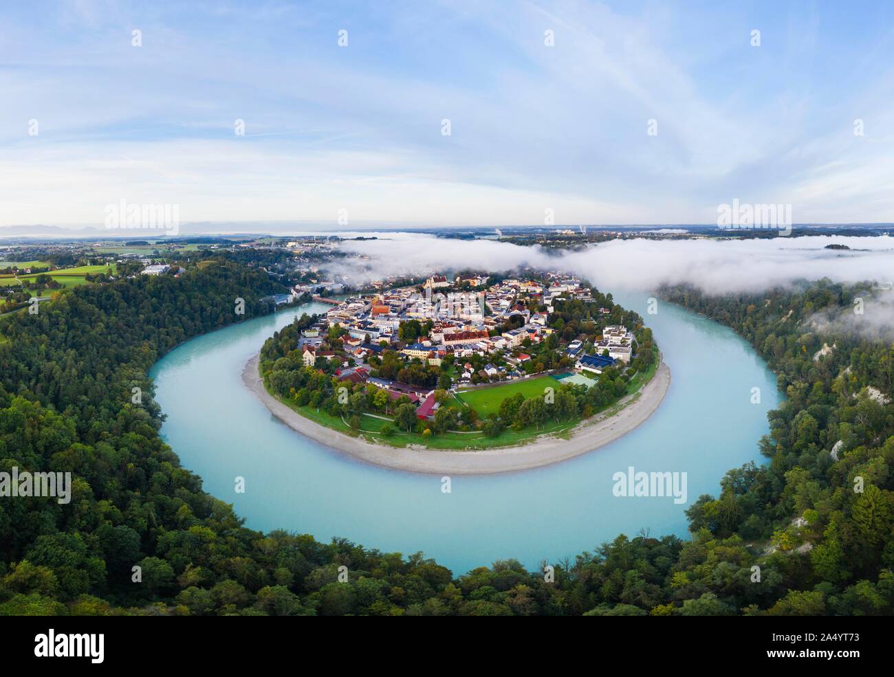 Old town in river bend of the Inn with fog, water castle at the Inn ...