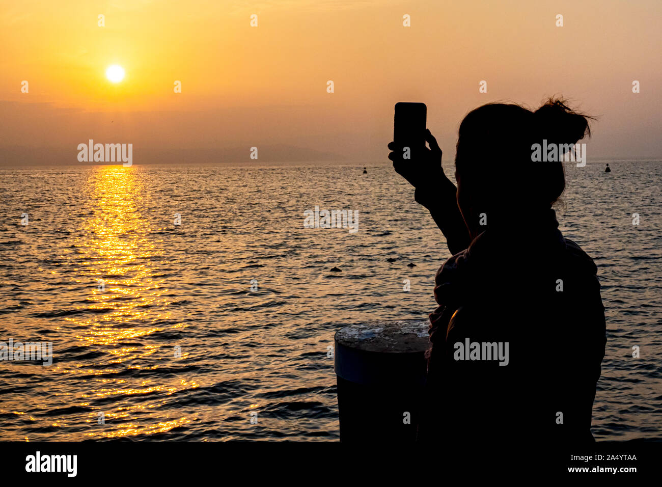 Girl making a selfie photo at sunset on the lakeside Stock Photo - Alamy