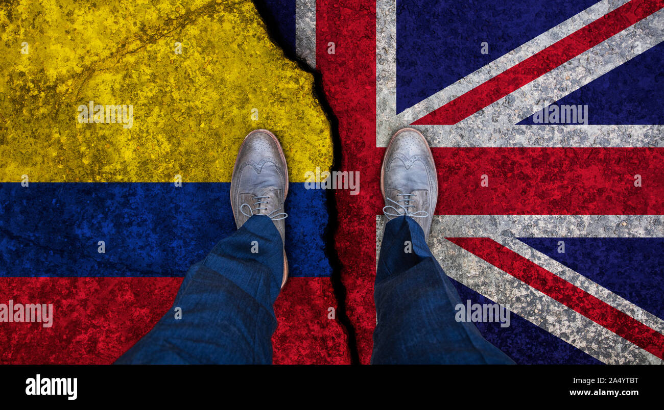 Business man stands on cracked flag of UK and Colombia. Political ...