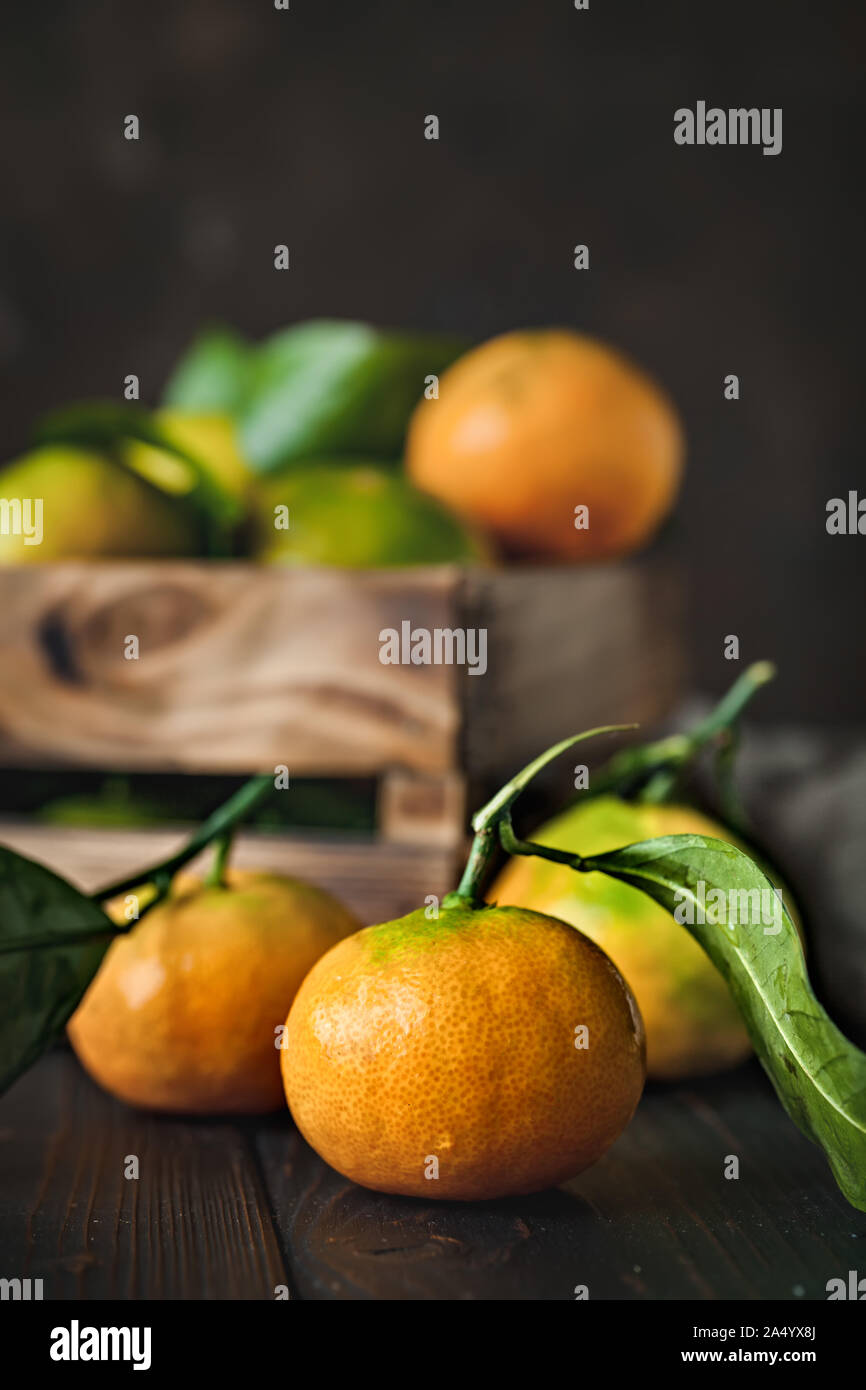 Tangerines with leaves on an old fashioned country table. Selective ...