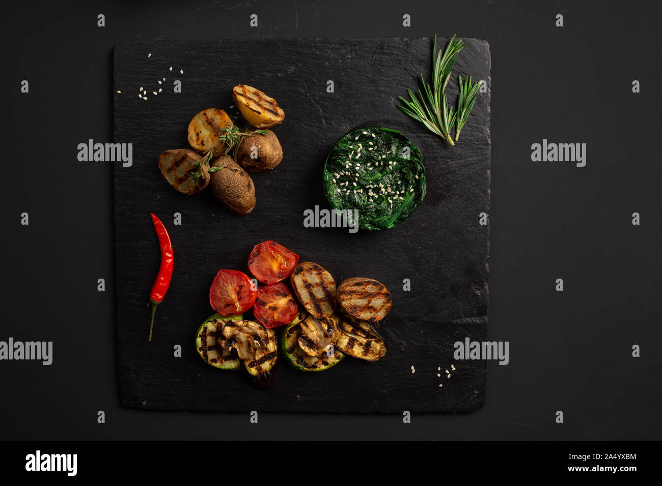 chuka salad and baked vegetables on a black board decorated with pepper ...