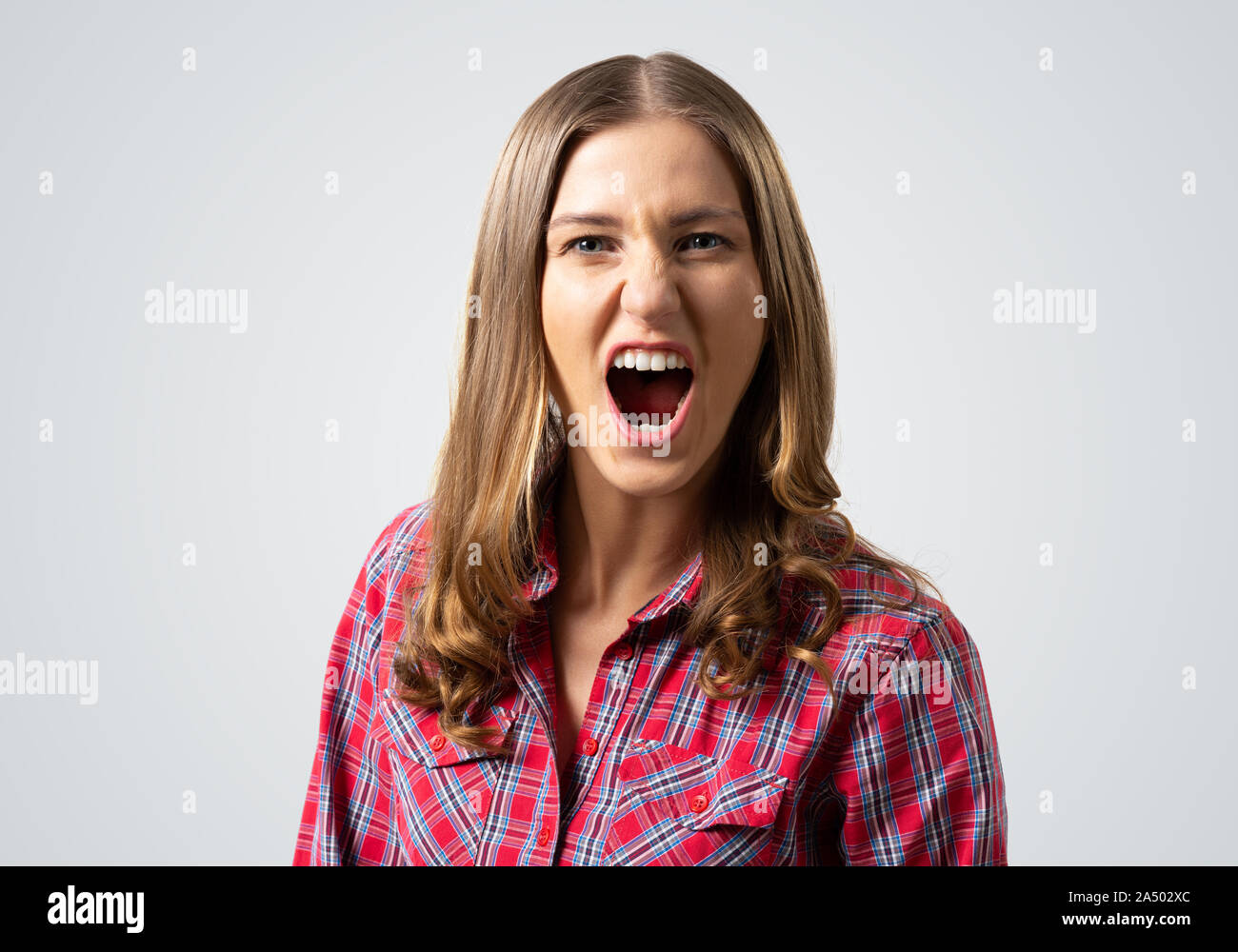 Frenzied young woman screaming with anger. Emotional girl has furious ...