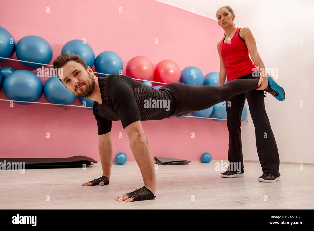 Young couple doing exercises in a gym Stock Photo - Alamy