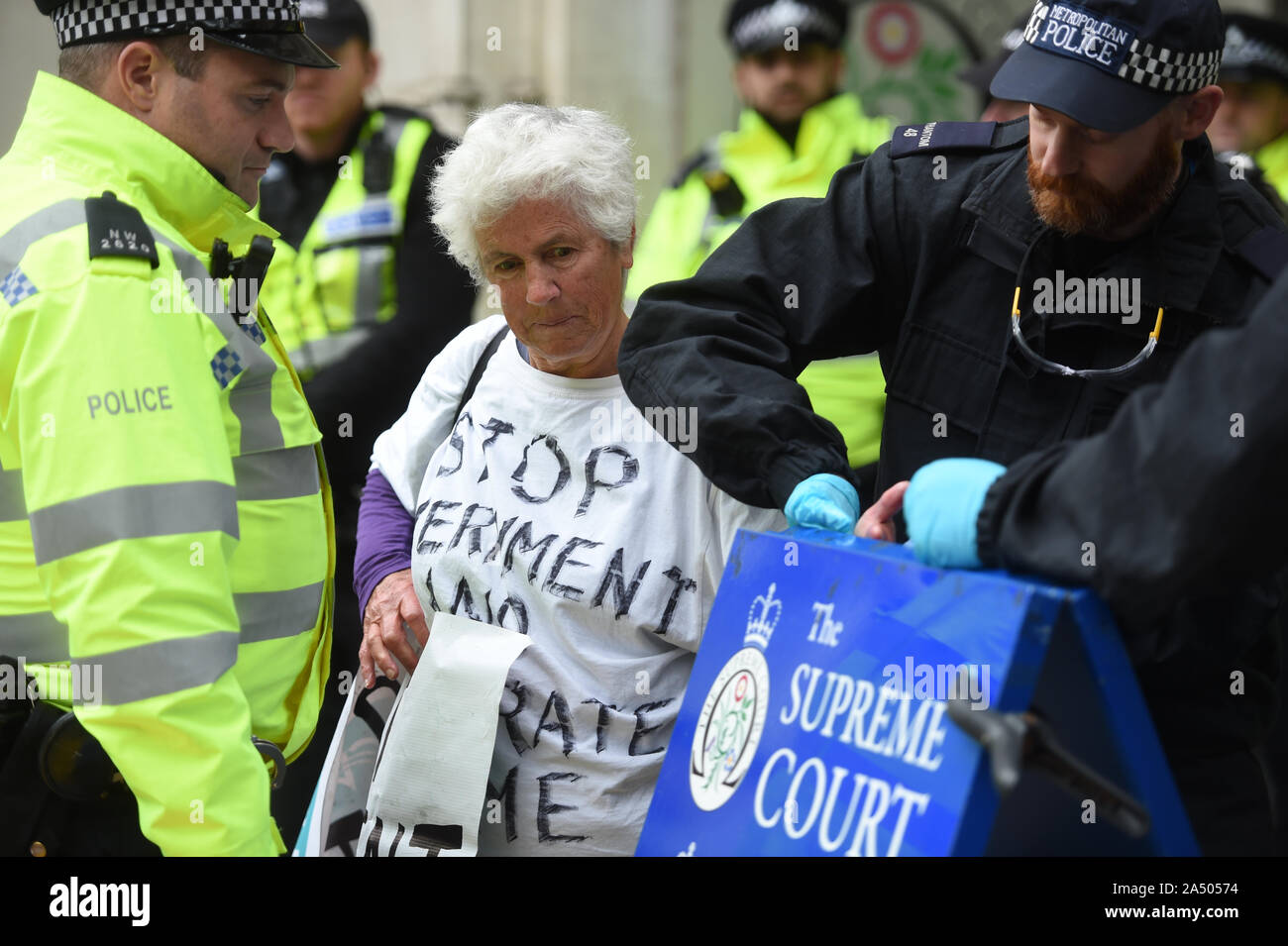 A protester who has glued herself to a sign outside the Supreme Court ...