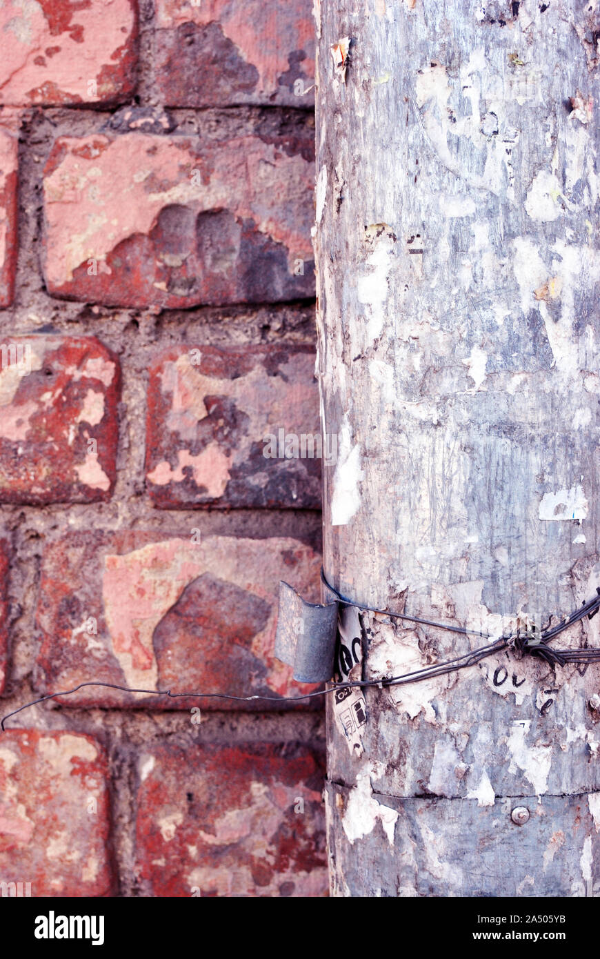 Rusty drain pipe with coiled wire on red brick wall close up detail ...