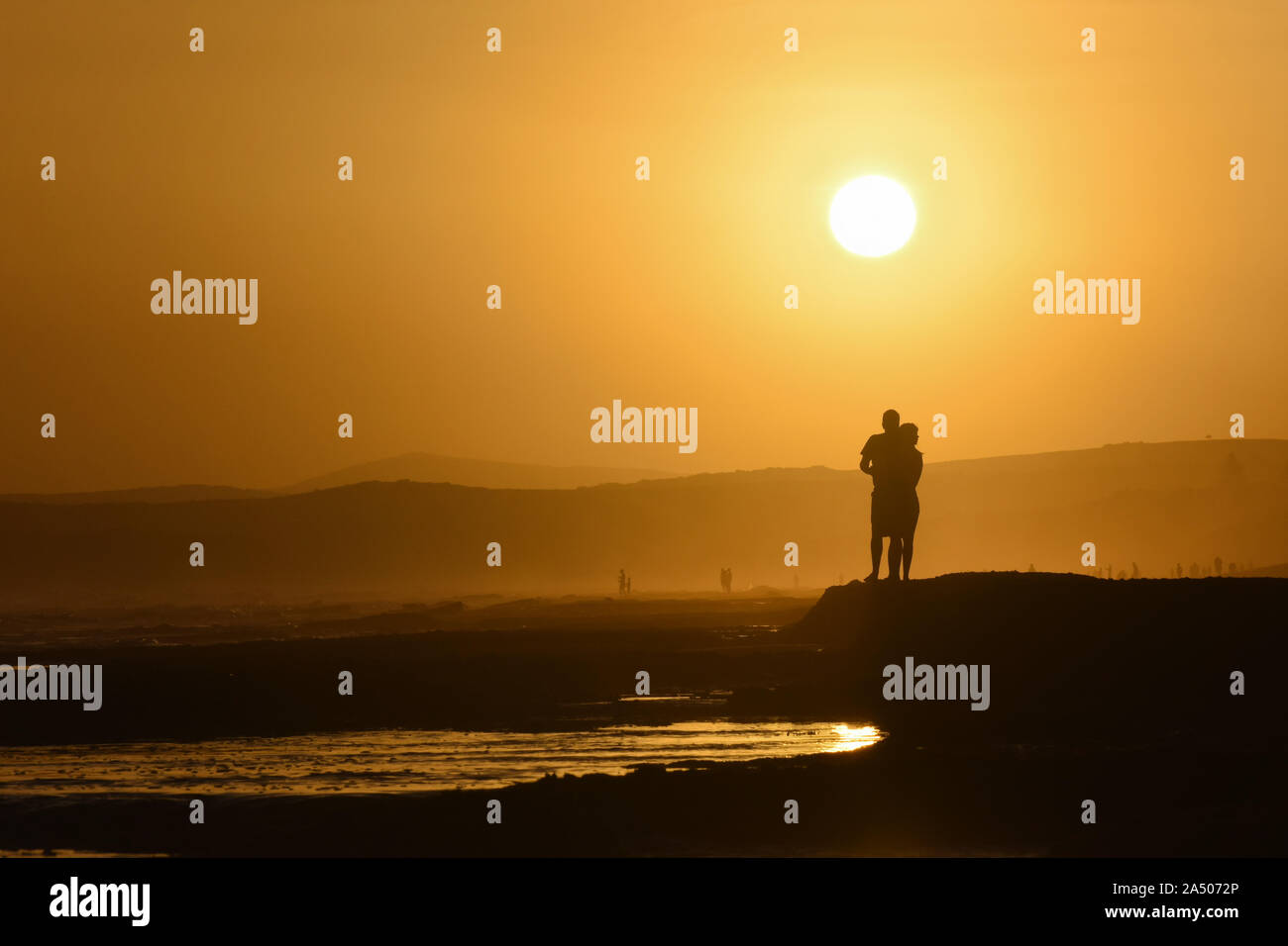 Young Couple On Vacation Beach Waiting For The Sunset Stock Photo - Alamy