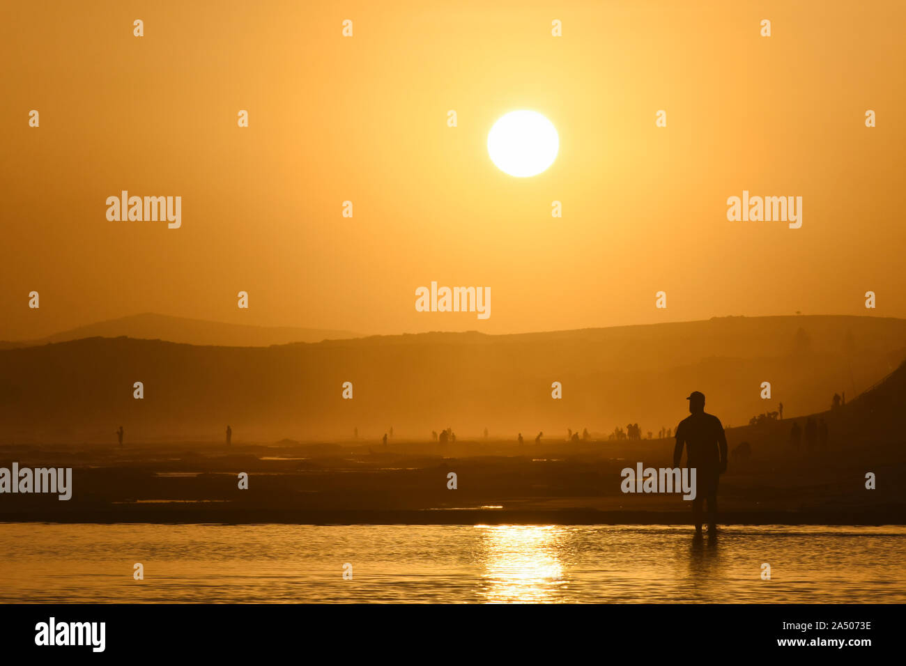 Silhouette of man standing on the beach watching sunset hi-res stock ...