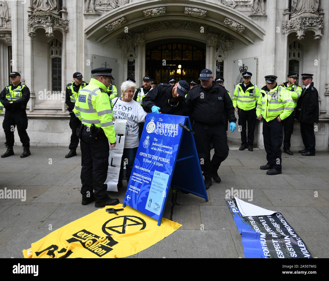 A protester who has glued herself to a sign outside the Supreme Court ...
