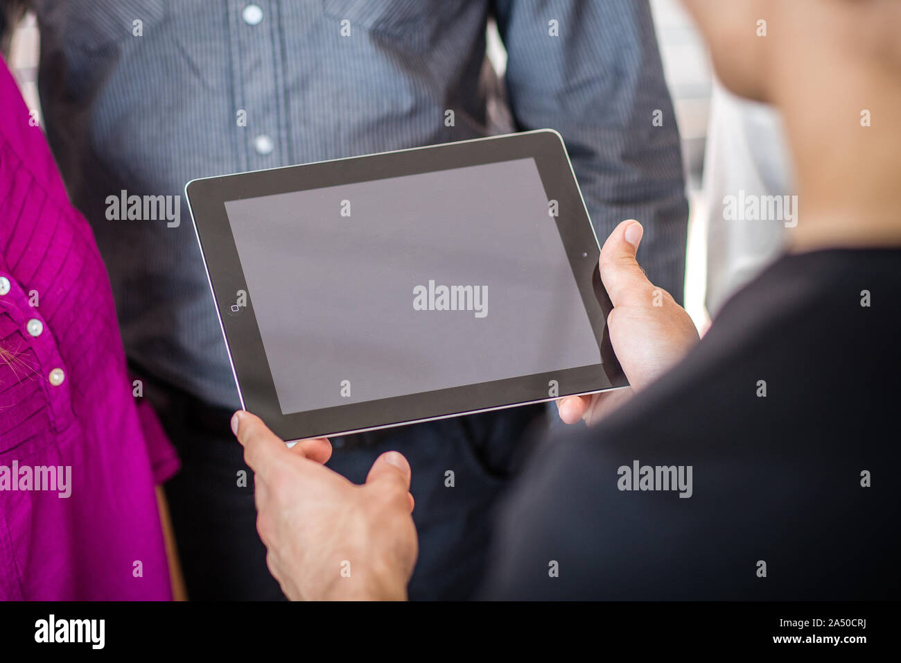 The team is looking at the tablet - teamwork Stock Photo - Alamy