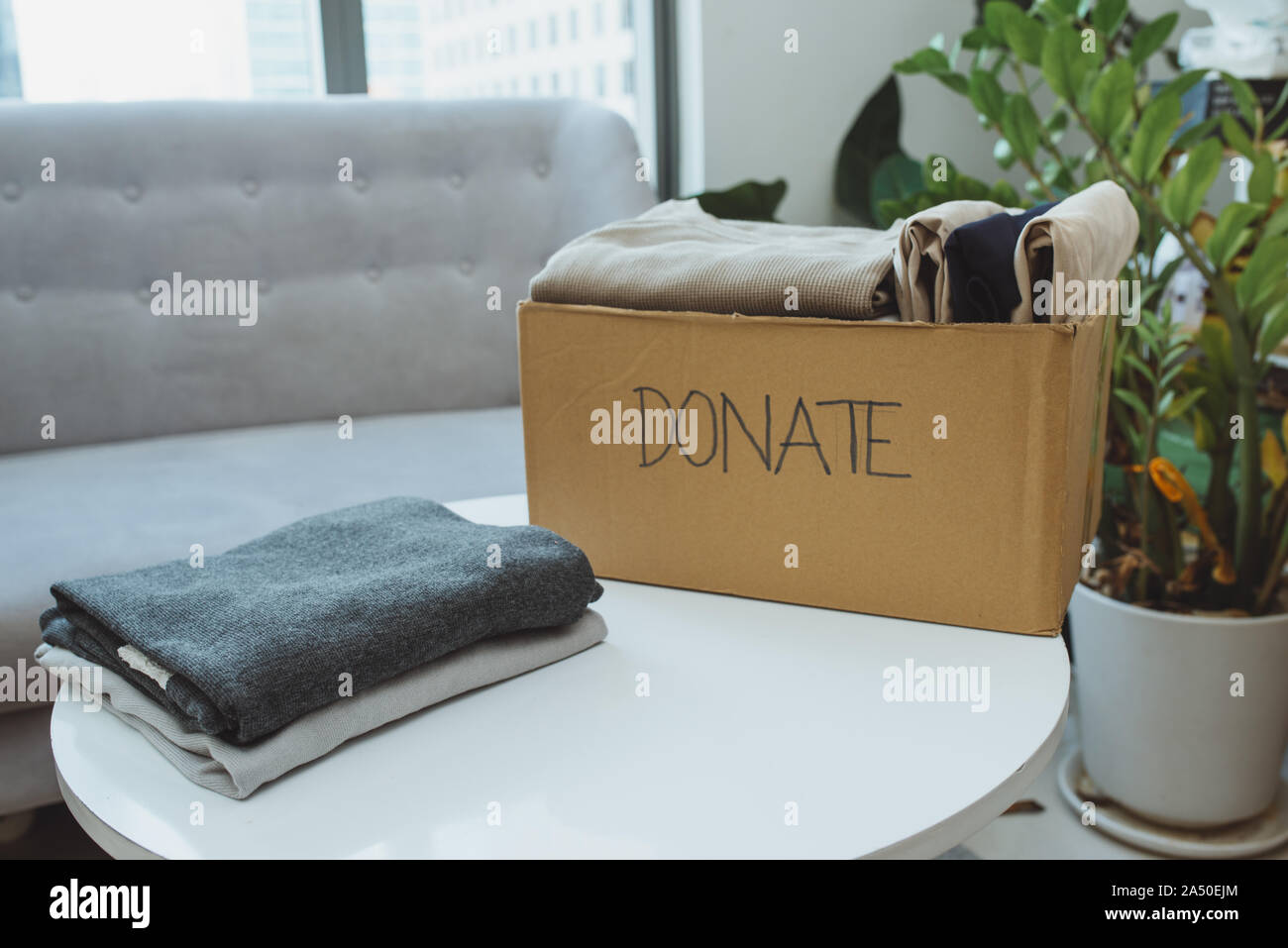 Donation box and casual clothes in livingroom Stock Photo - Alamy