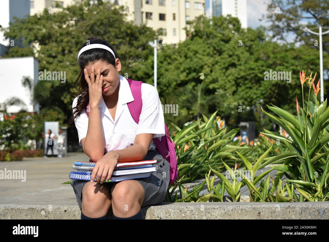 Sad Girl Student Wearing Uniform With Notebooks Sitting Stock Photo - Alamy